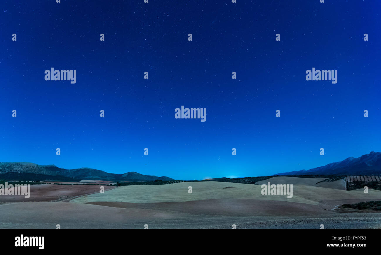 Nighttime view over fields to mountains at night Stock Photo - Alamy