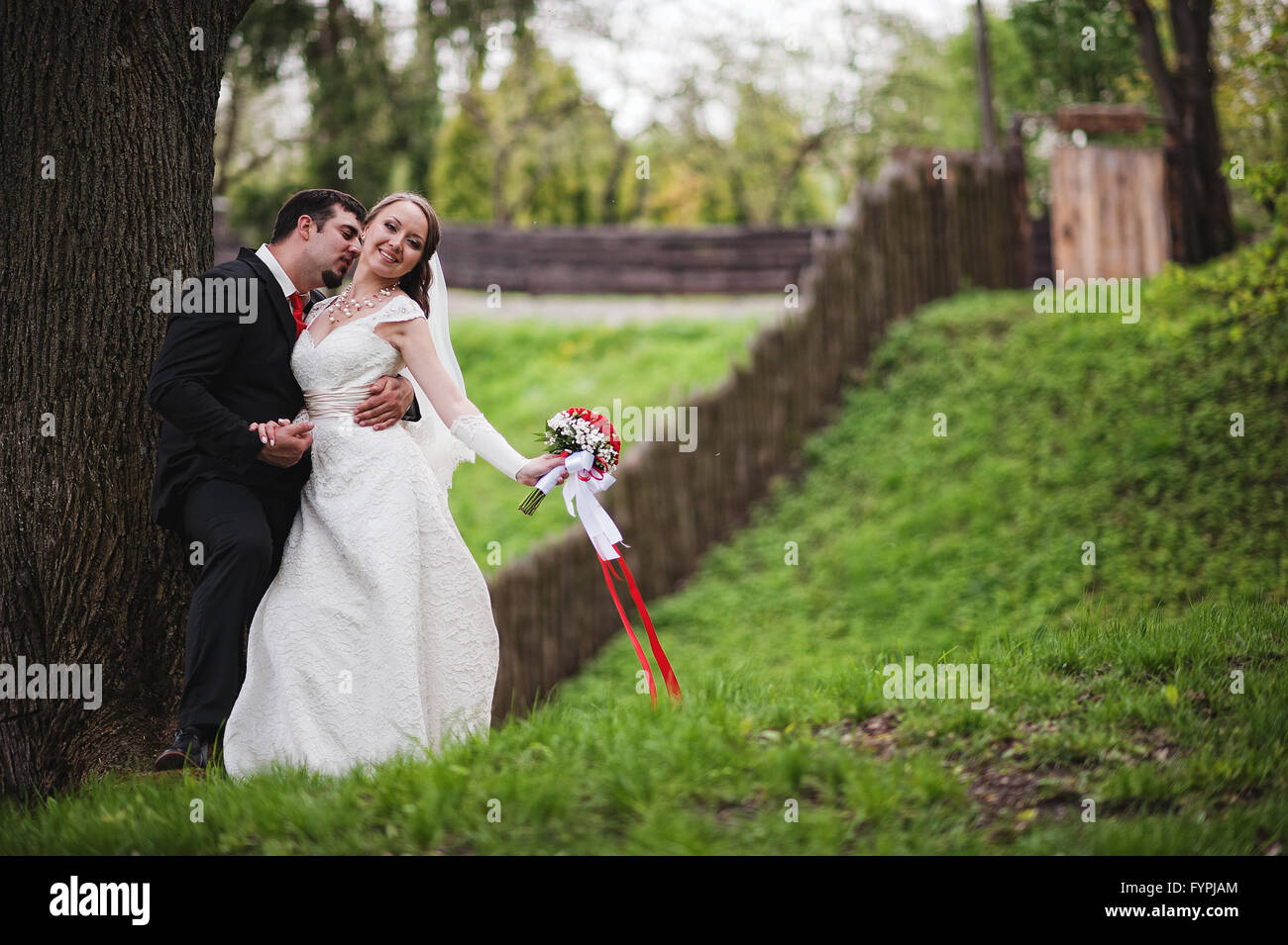 wedding couple near a wooden fence Stock Photo - Alamy
