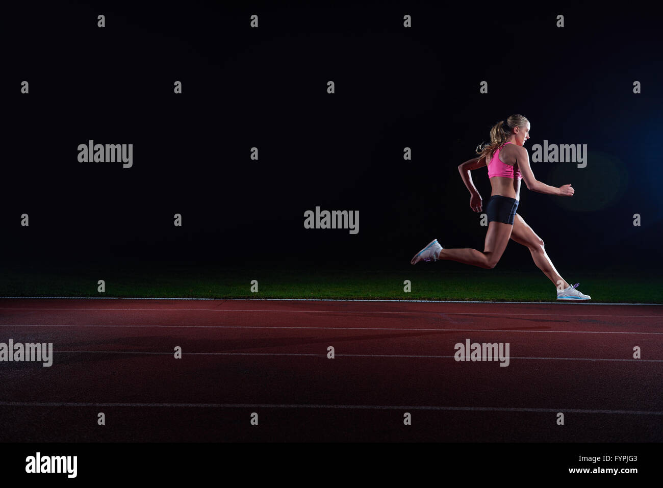 Athletic woman running on track Stock Photo - Alamy