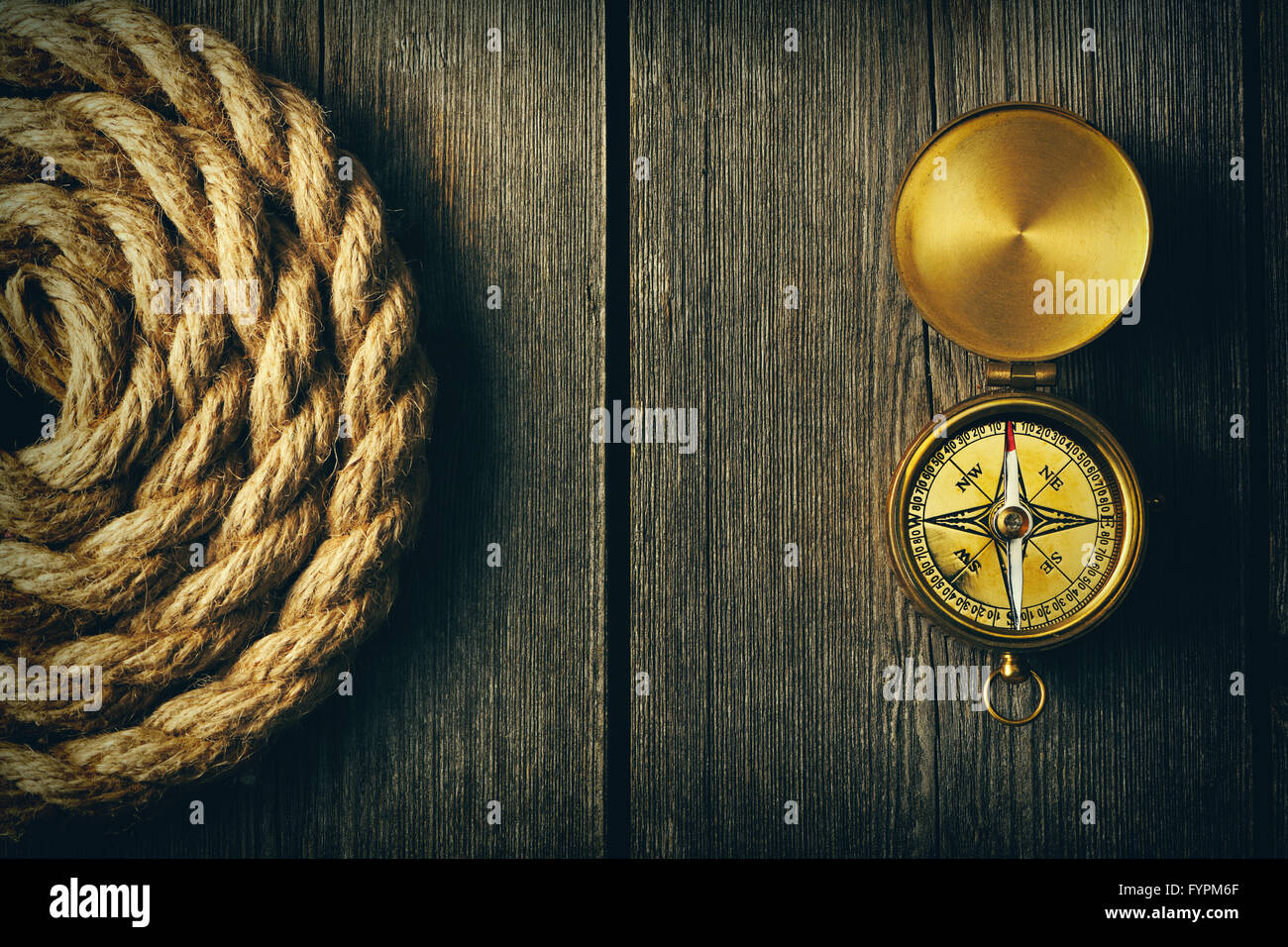 Antique compass and rope over wooden background Stock Photo - Alamy