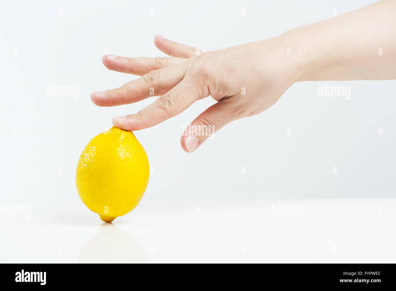 Lemon and a female hand Stock Photo - Alamy