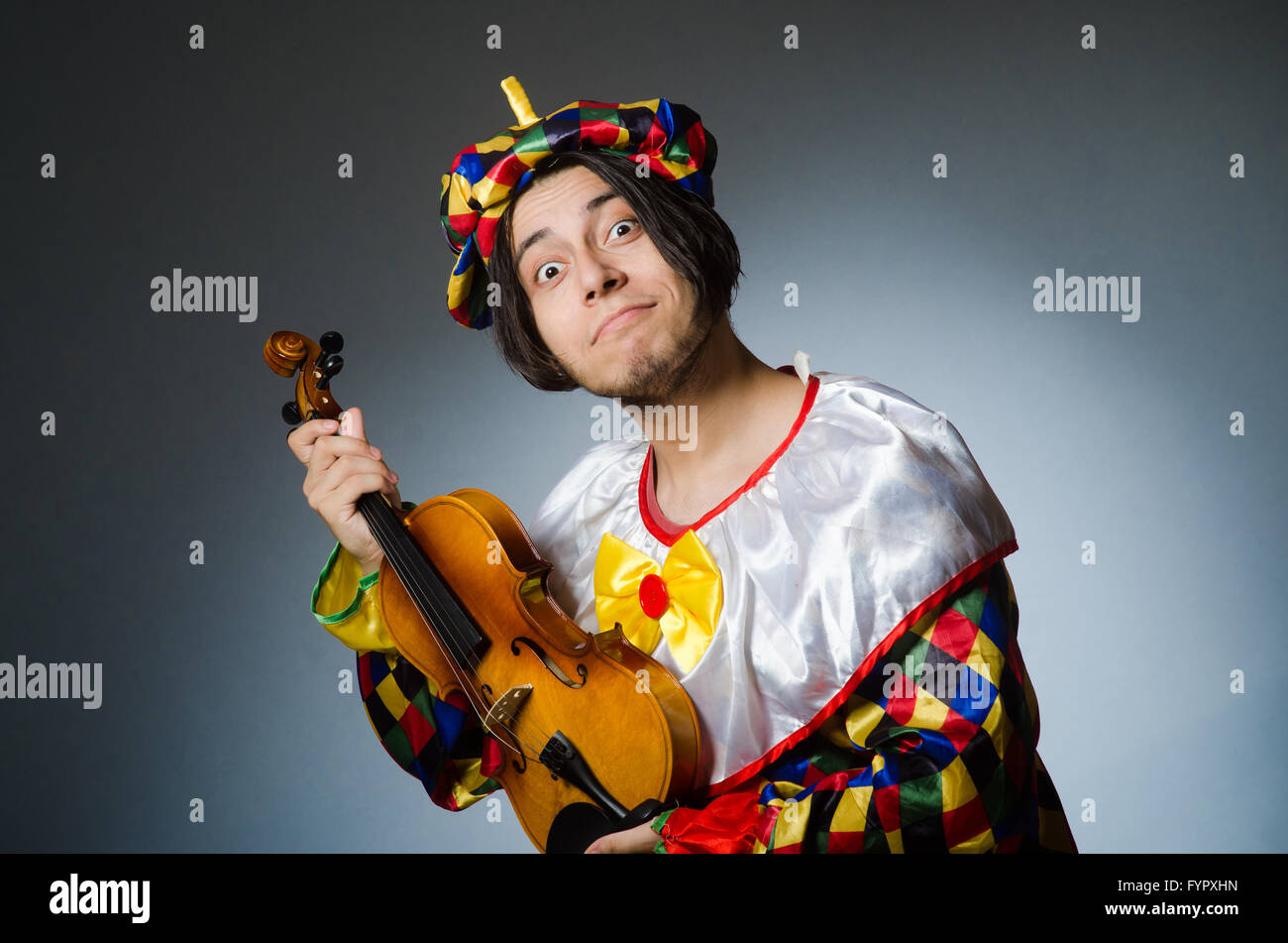 The funny violin clown player in musical concept Stock Photo - Alamy