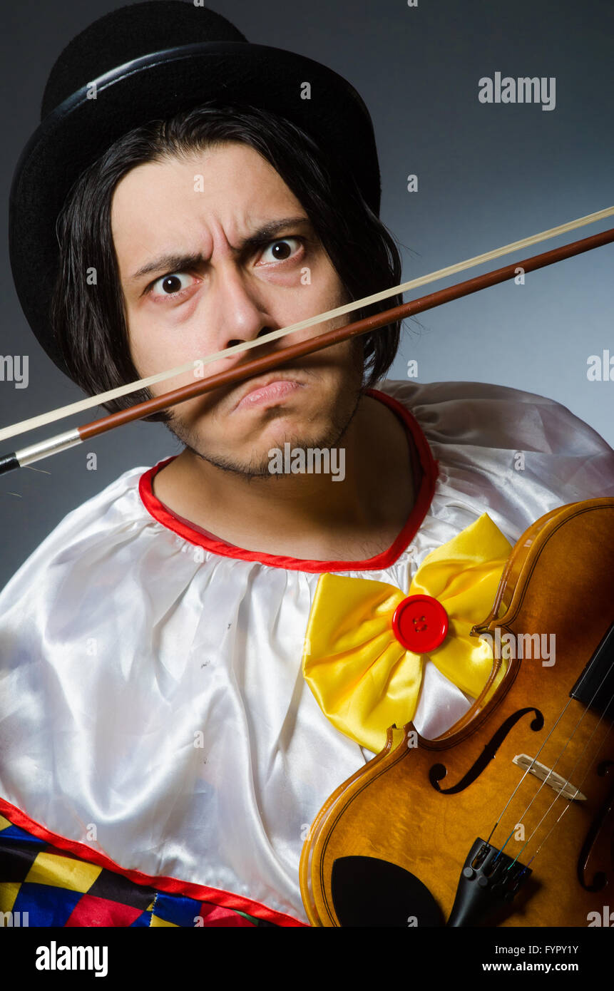 The funny violin clown player in musical concept Stock Photo - Alamy