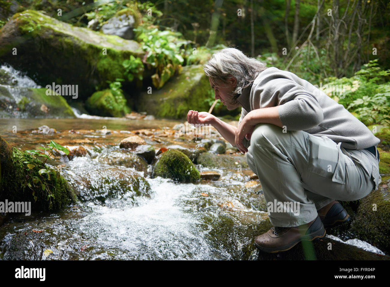 man drinking fresh water from spring Stock Photo - Alamy
