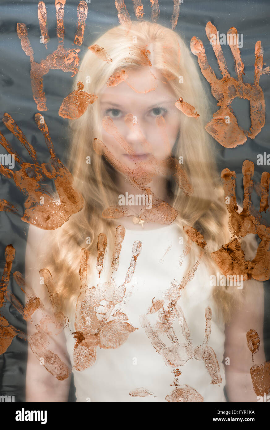 Young woman behind plastic sheet covered with handprints Stock Photo ...
