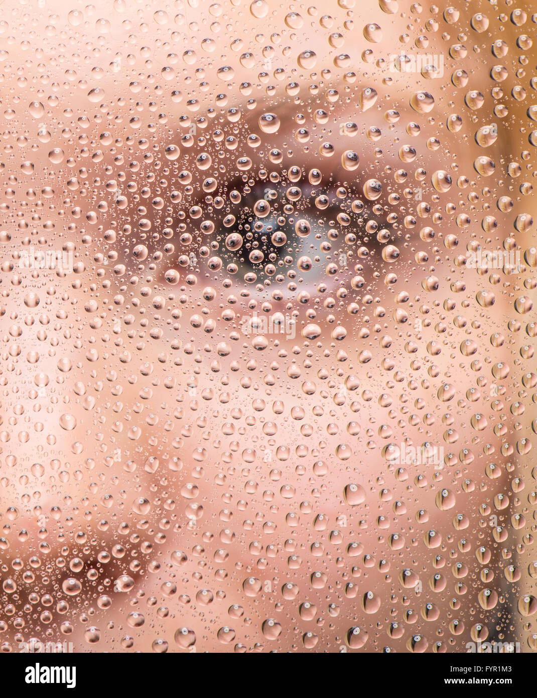 Girl's face through glass pane covered with raindrops Stock Photo - Alamy