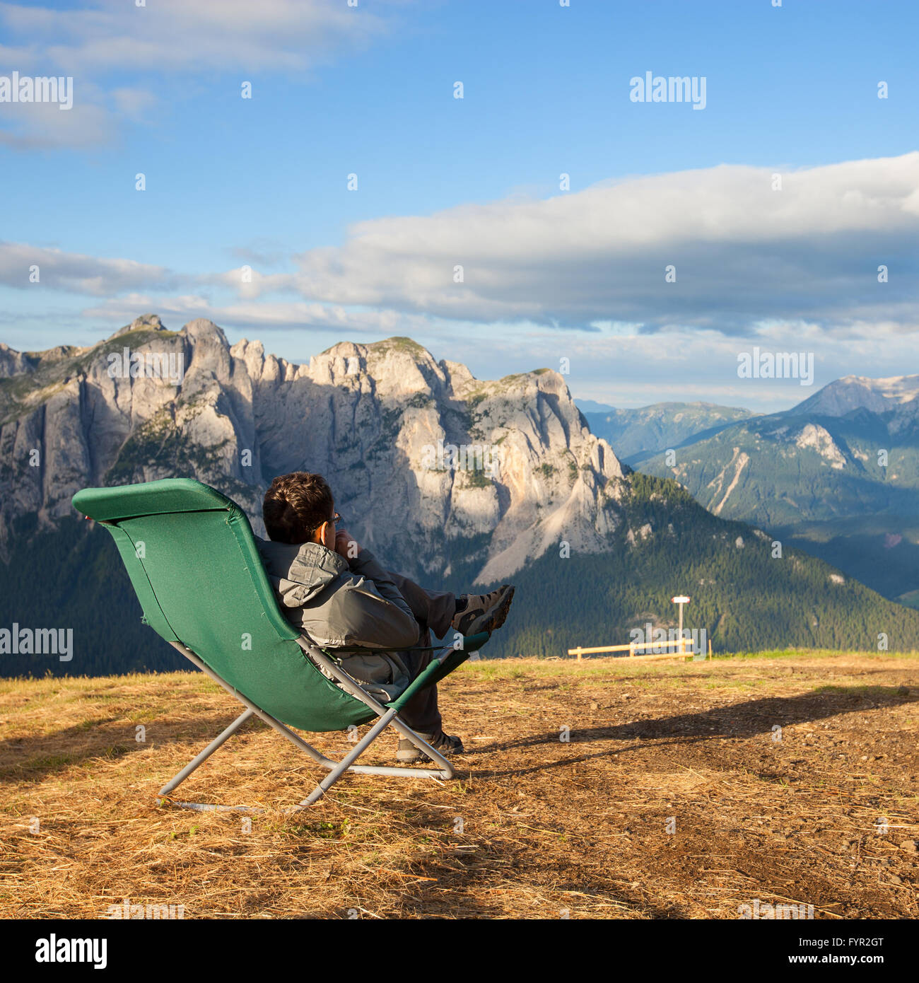 Man sitting in lounge chair Stock Photo - Alamy