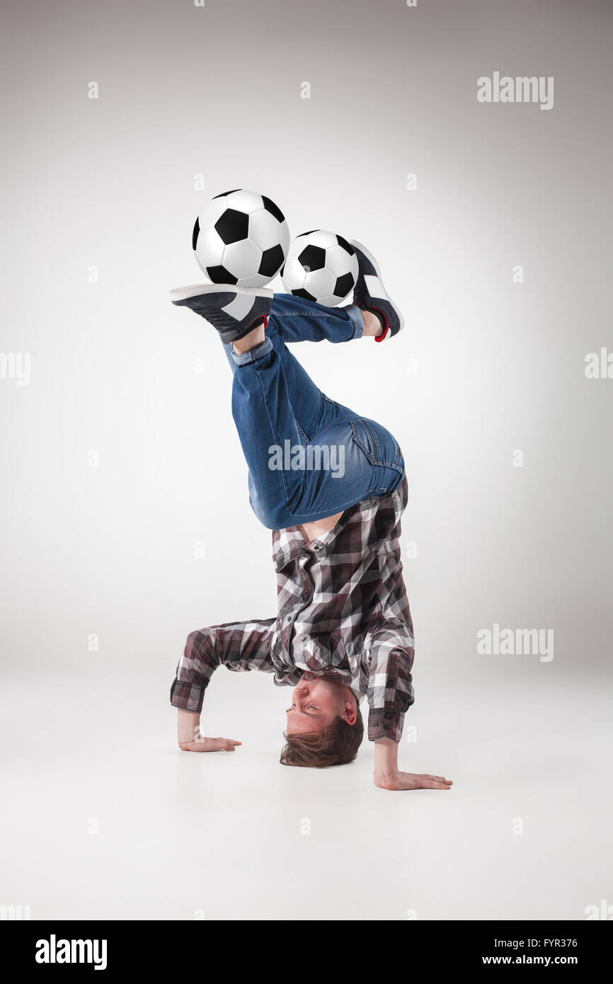 Portrait of young man, practicing yoga with football balls Stock Photo ...