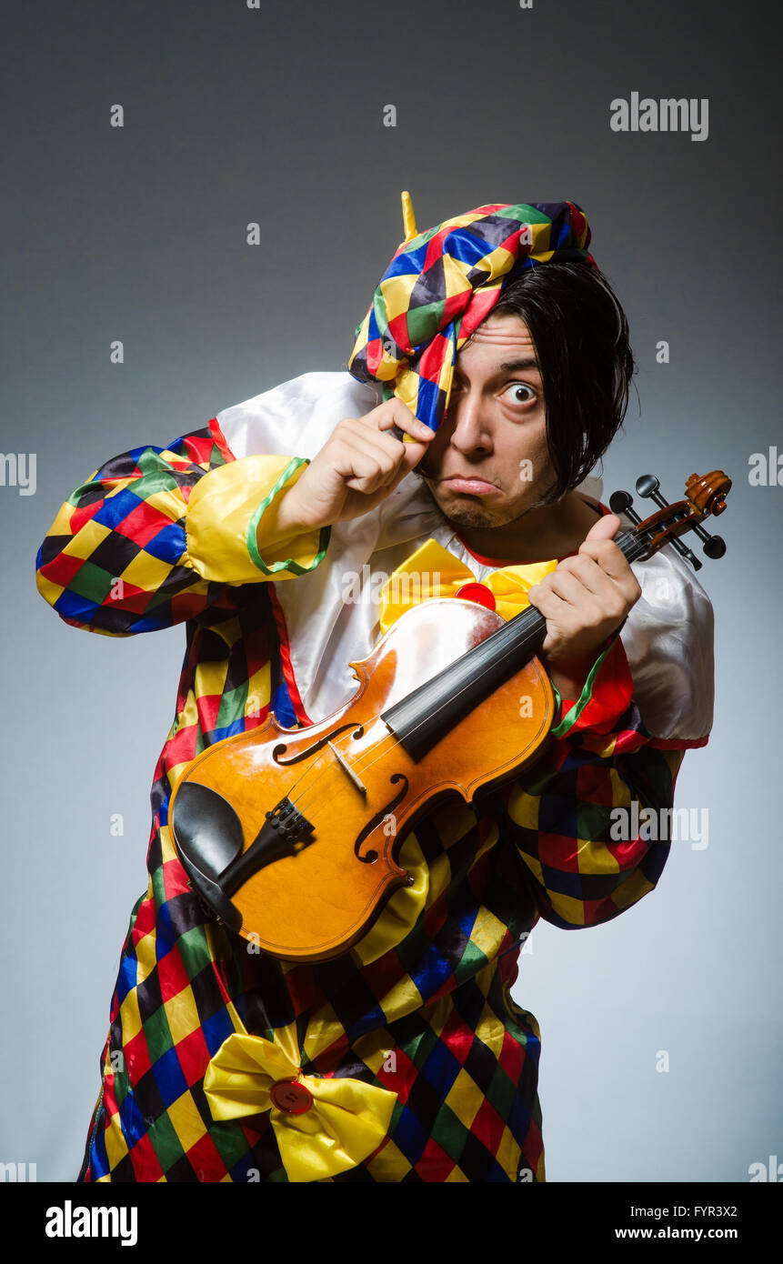 The funny violin clown player in musical concept Stock Photo - Alamy