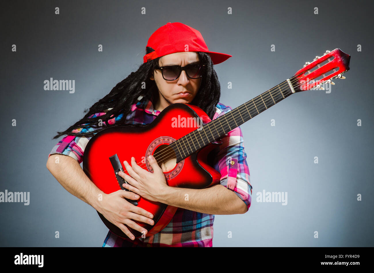 The funny man playing guitar in musical concept Stock Photo - Alamy