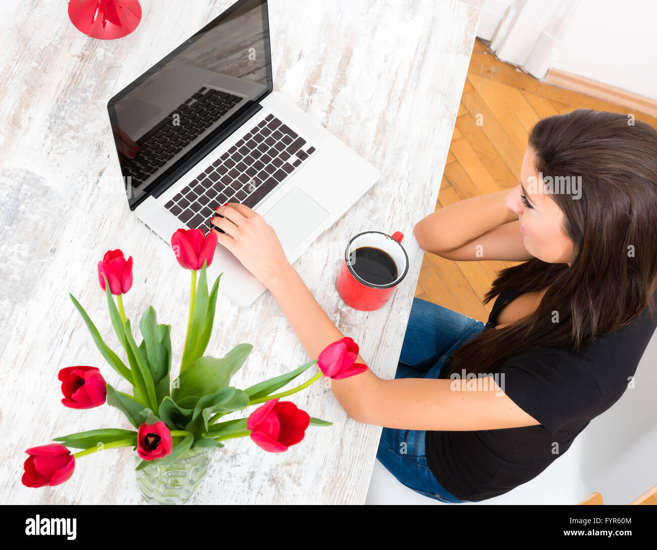 Young beautiful woman smiling while using a Laptop at home Stock Photo ...