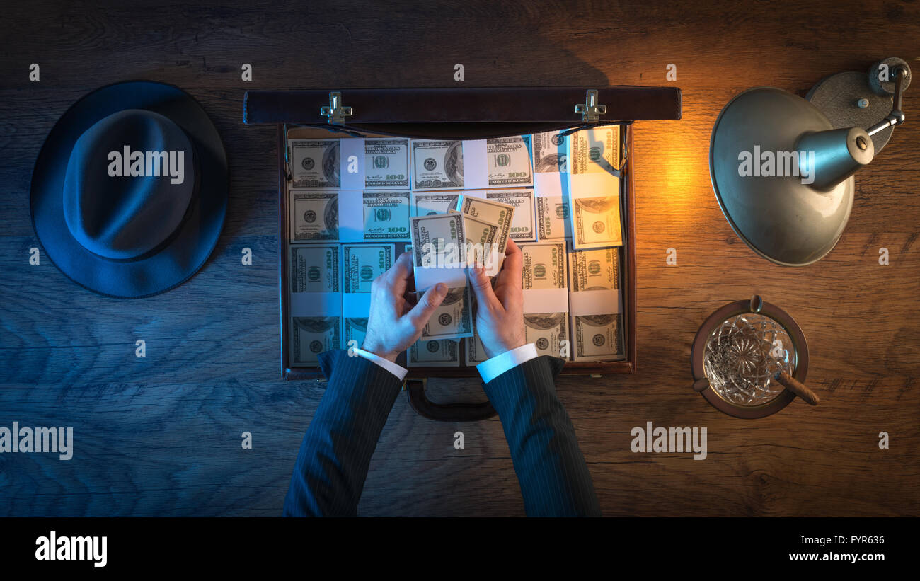 Vintage rich businessman's desk with a briefcase filled with dollar ...