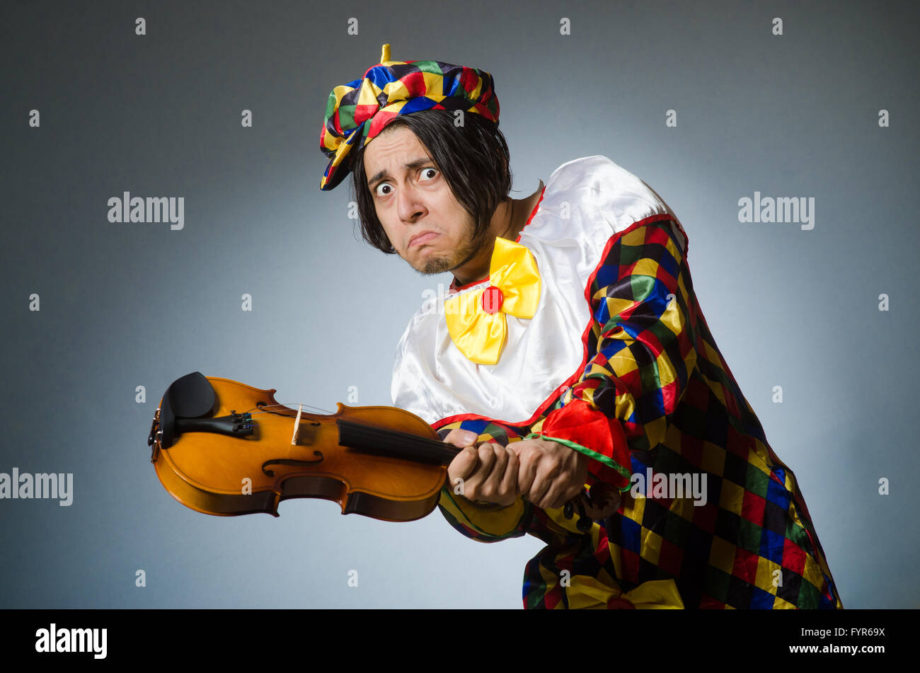 The funny violin clown player in musical concept Stock Photo - Alamy