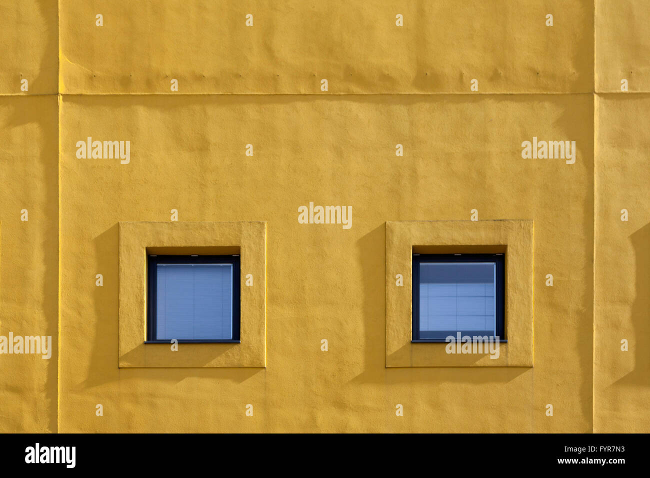 two square windows in a yellow wall Stock Photo - Alamy