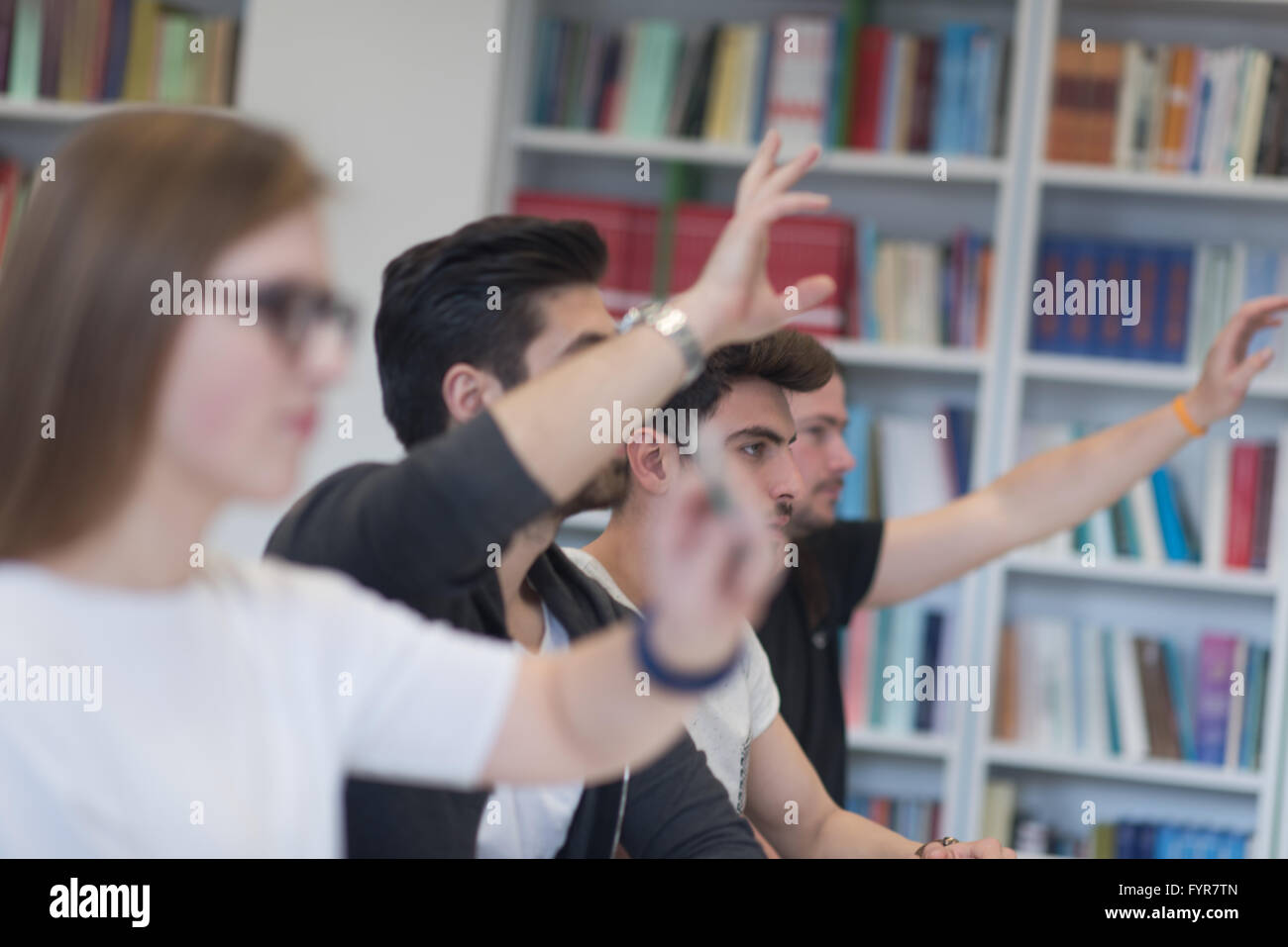 group of smart students raise hands up in school classroom on class ...