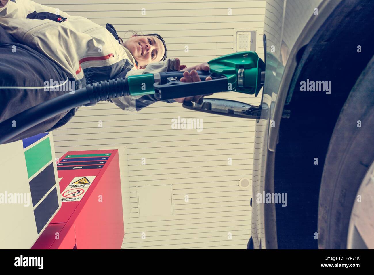 Attractive woman pumping gas Stock Photo - Alamy