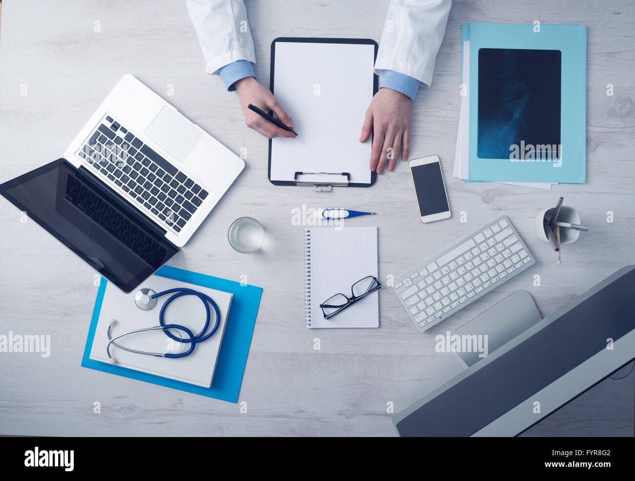 Professional doctor writing medical records on a clipboard with ...