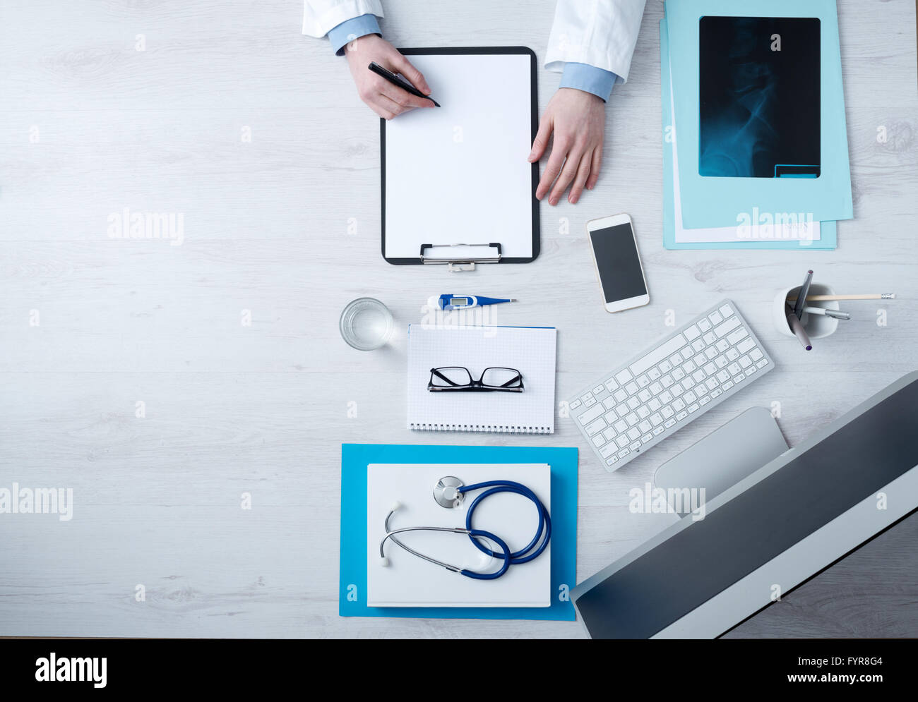 Professional doctor writing medical records on a clipboard with ...