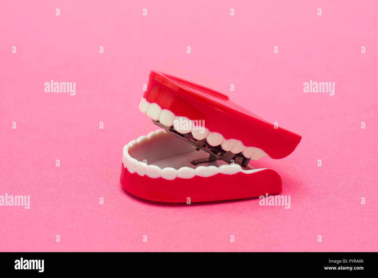Wind up clockwork teeth on pink background Stock Photo - Alamy