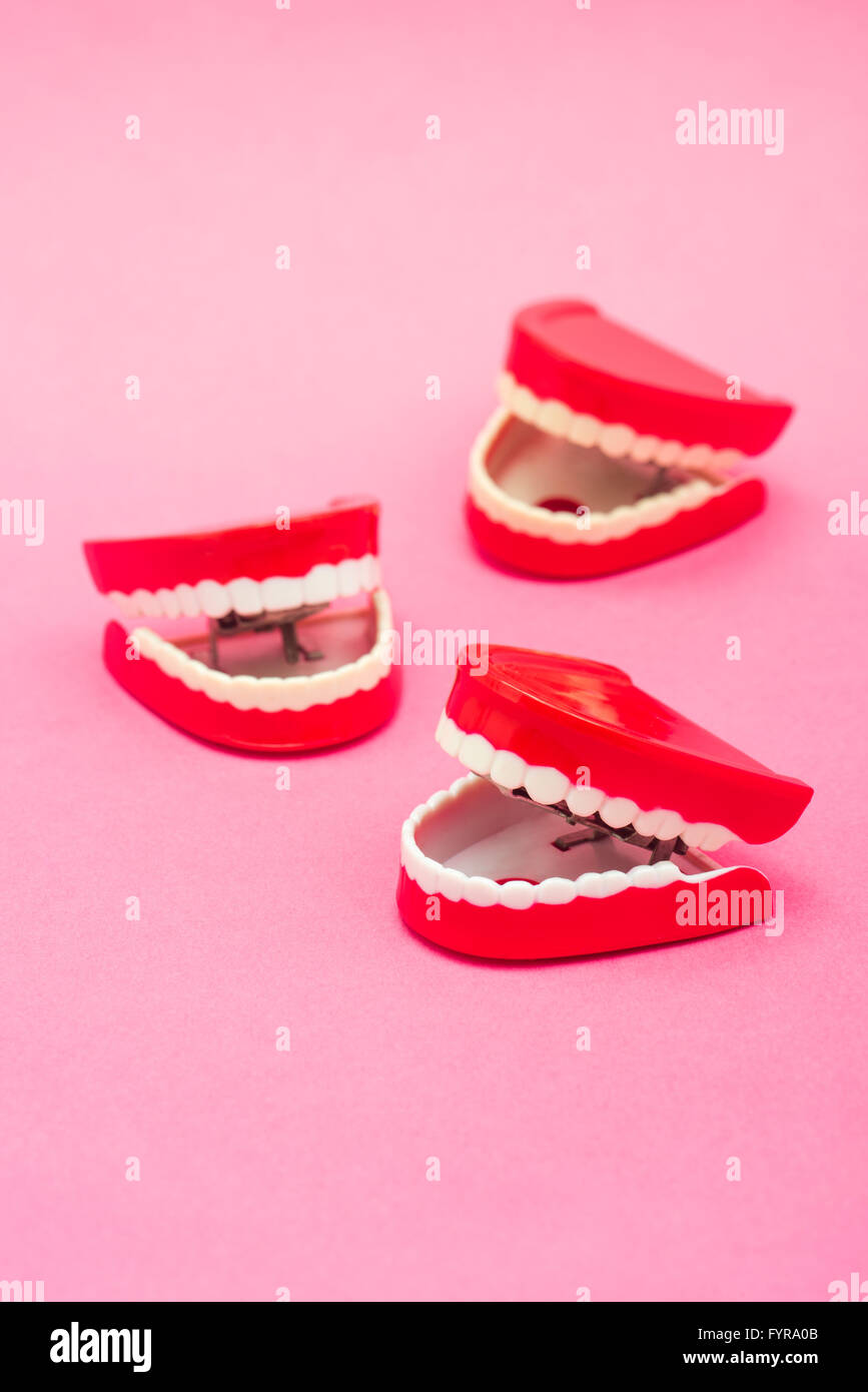 Wind up clockwork teeth on pink background Stock Photo - Alamy