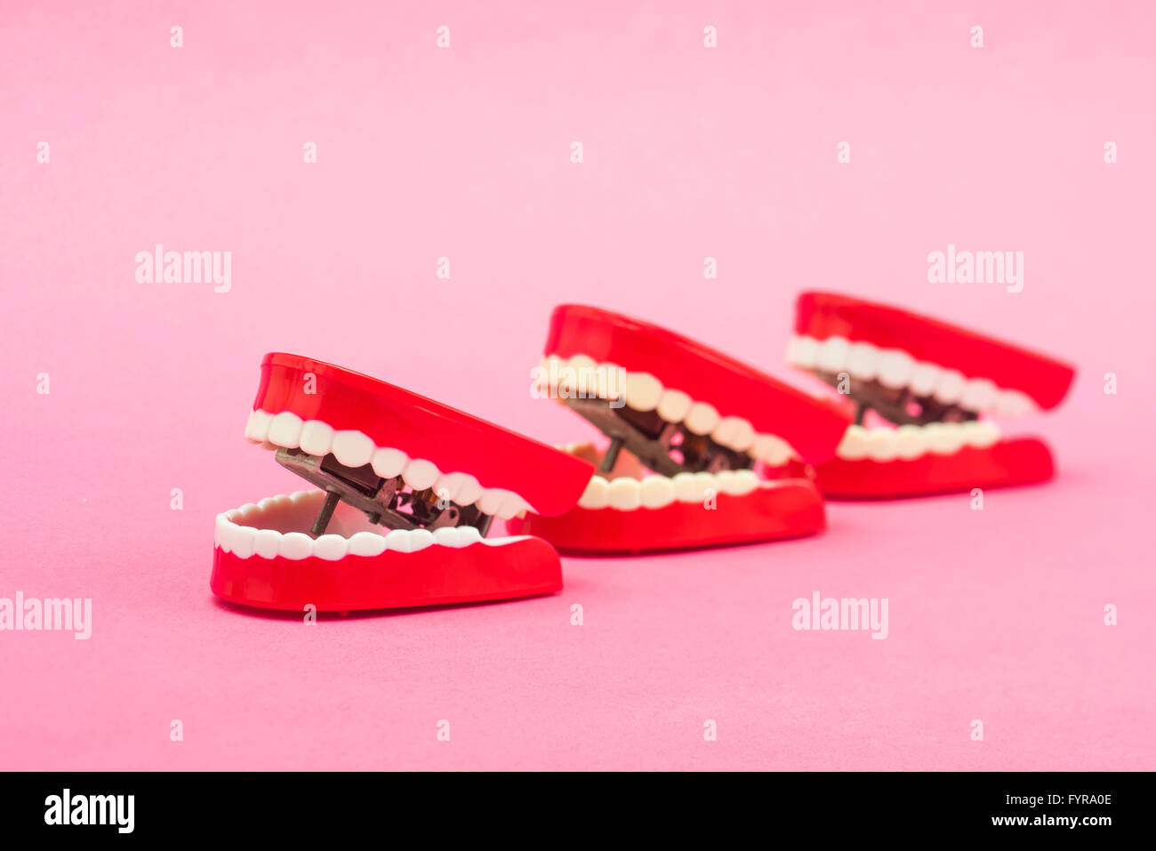 Wind up clockwork teeth on pink background Stock Photo - Alamy