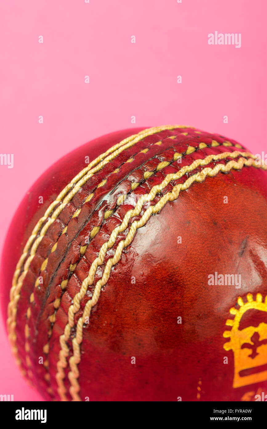 Cricket ball on pink background Stock Photo - Alamy