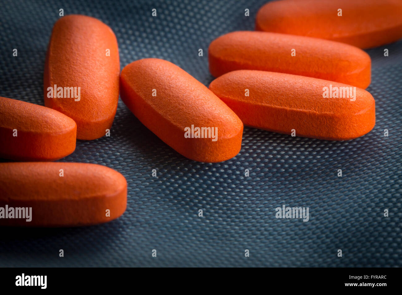 Macro close up orange pain killer pills on blue background Stock Photo ... Macro close up orange pain killer pills on blue background Stock Photo ...