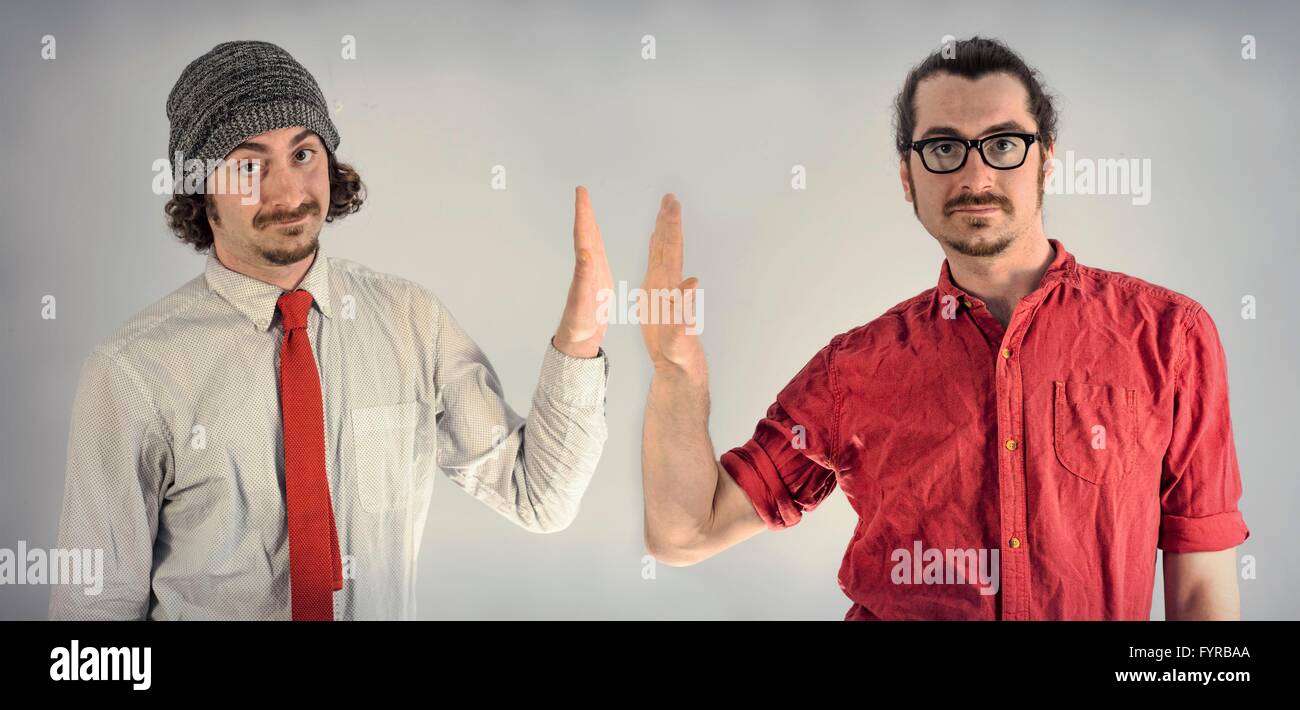 Twin adult men with beards high fiving eachother Stock Photo - Alamy