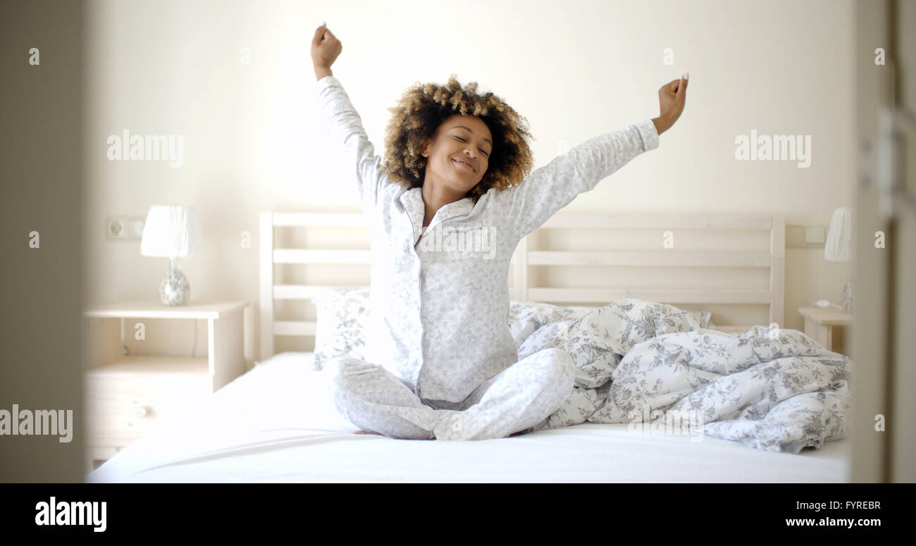 Young Woman Awaking On The Bed Stock Photo - Alamy