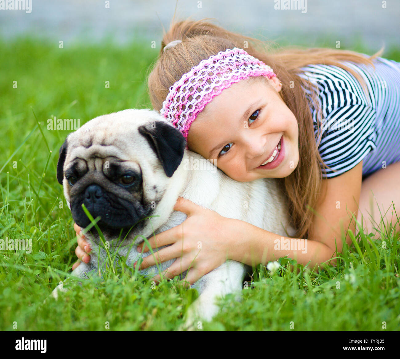 Little girl and her pug dog on green grass, outdoor shoot Stock Photo ...