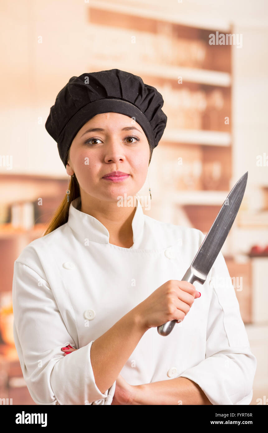 Woman chef wearing cooking outfit posing happily holding large metal ...