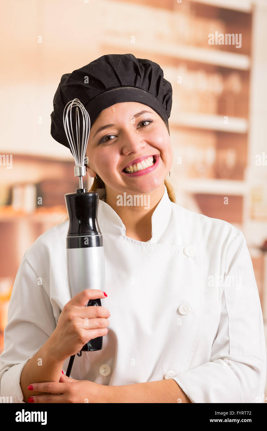 Woman chef wearing cooking outfit posing happily holding electric ...
