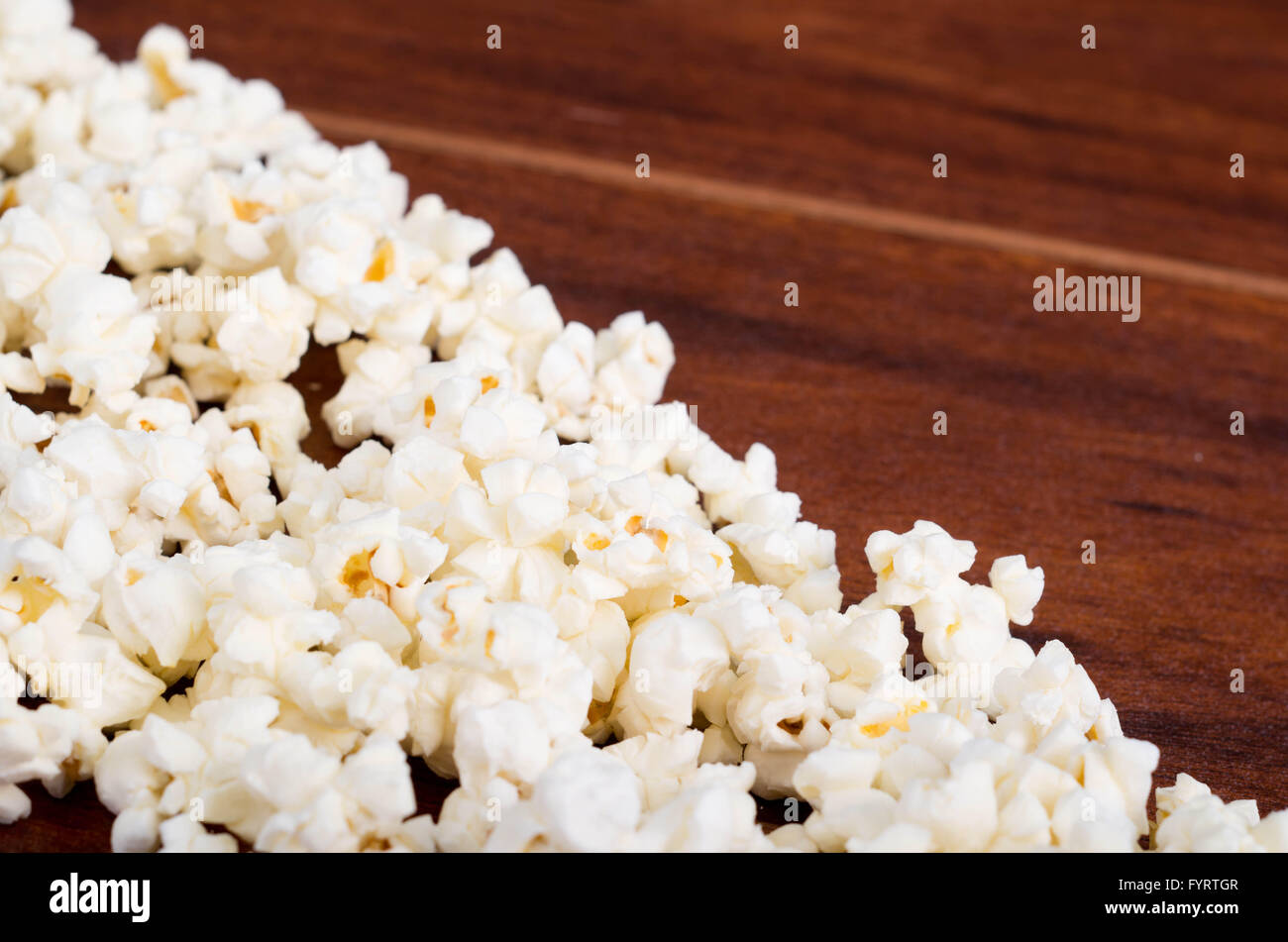 Closeup pile of white fluffy popcorn lying mixed together on wooden ...