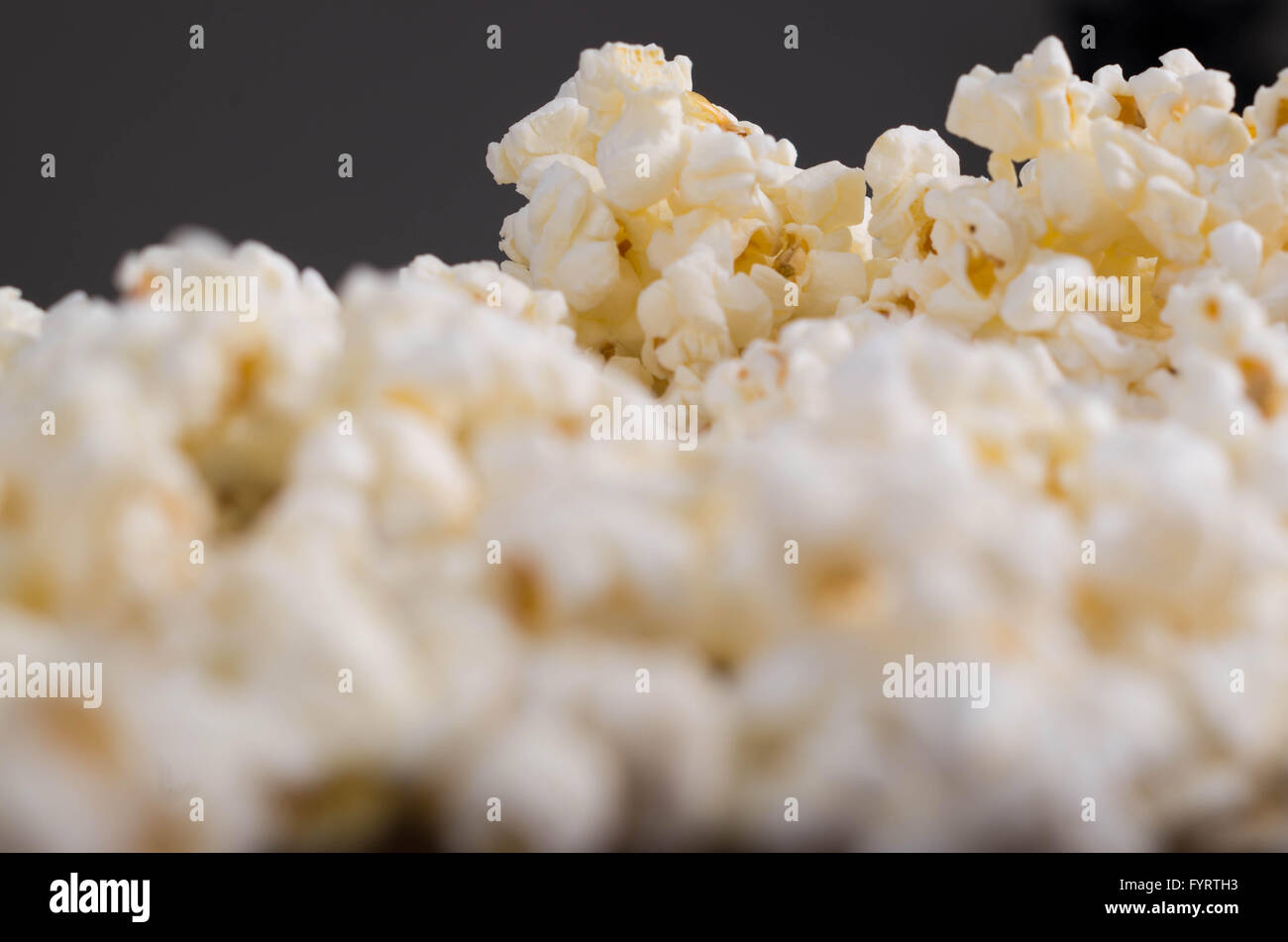 Closeup pile of white fluffy popcorn seen from low angle with grey ...