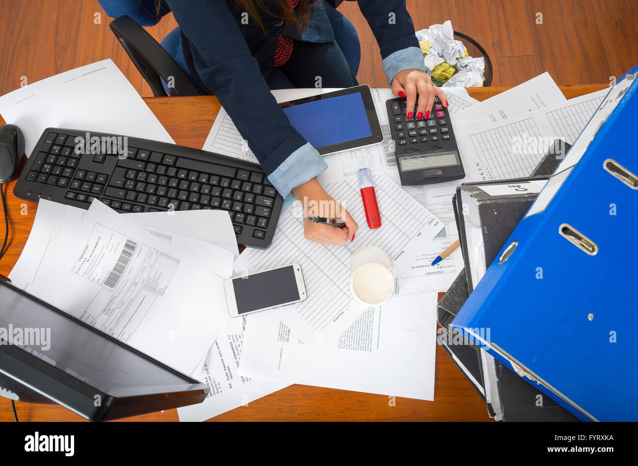 Office desk as seen from above, papers spread out, calculators ...