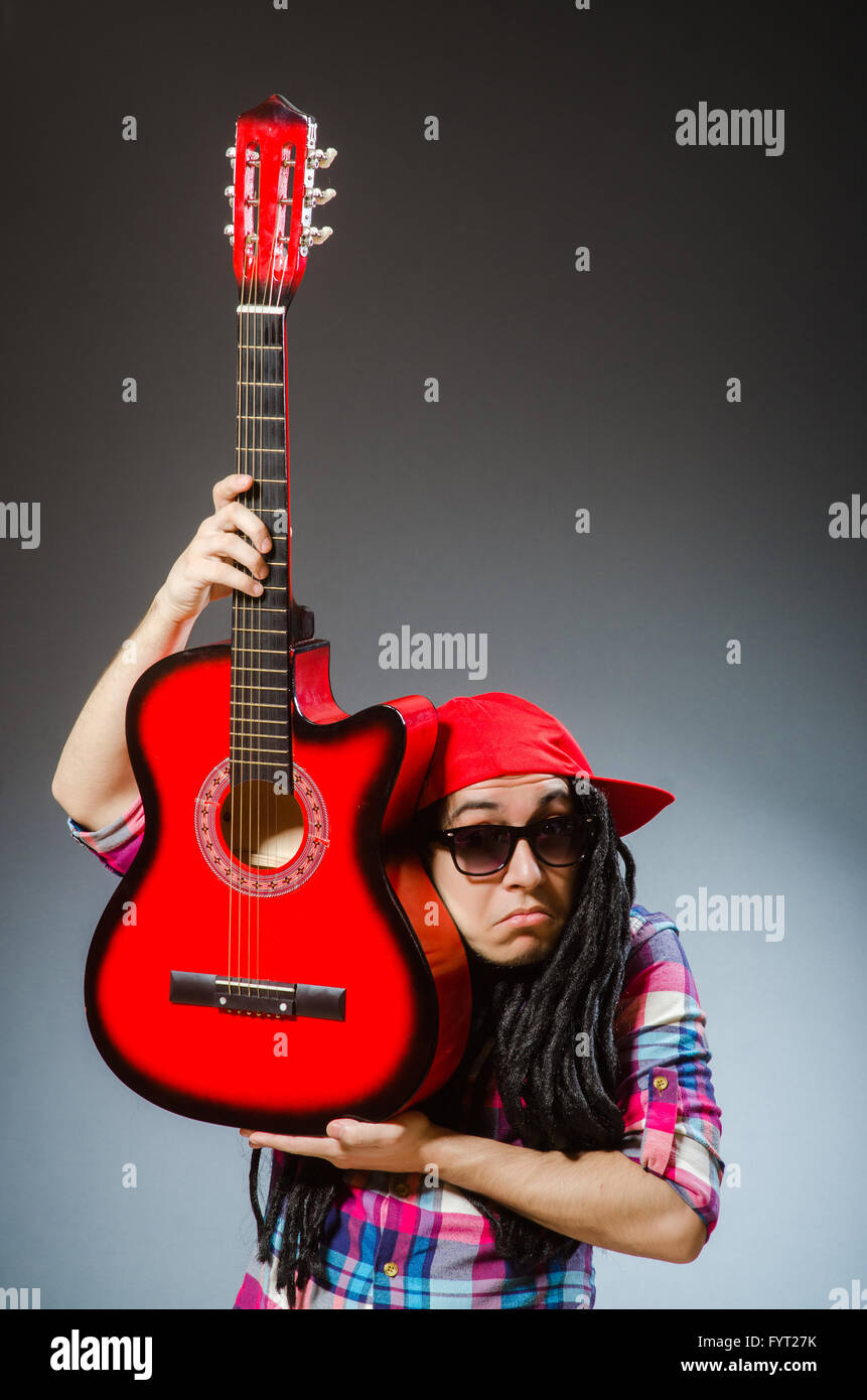 The funny man playing guitar in musical concept Stock Photo - Alamy