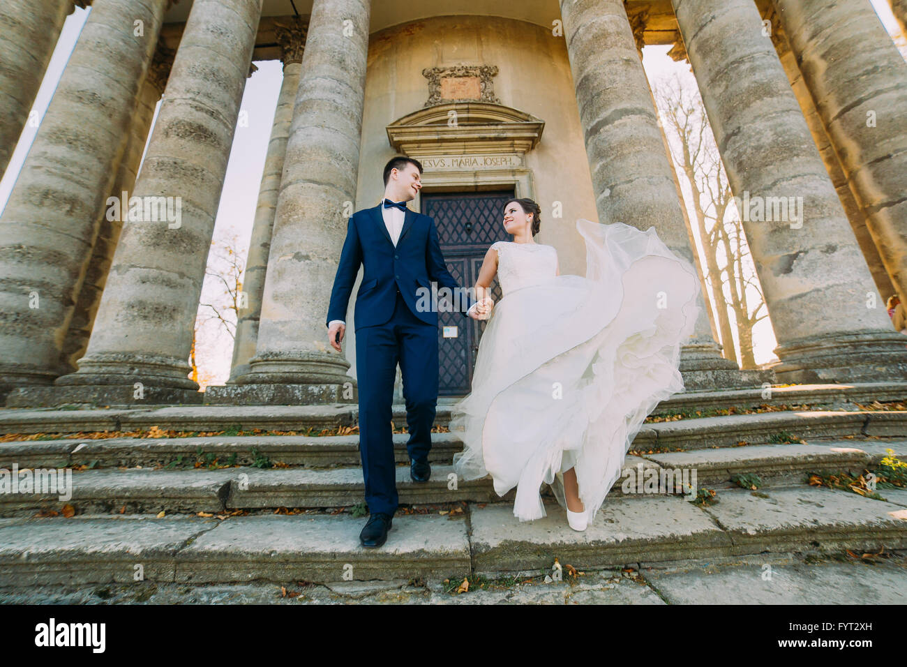 Romantic married couple bride and groom walking down stairs antique ...