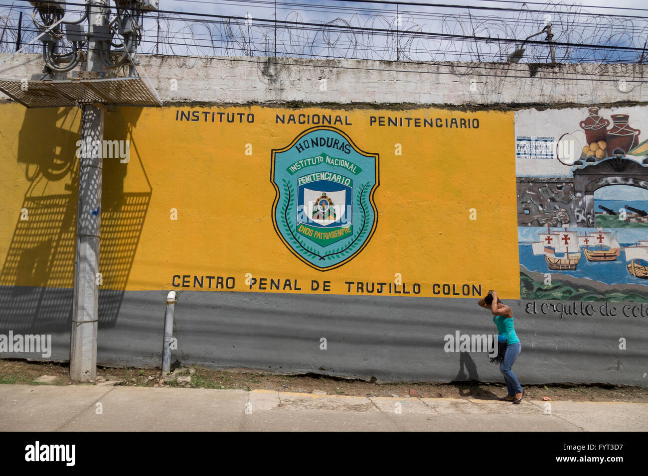 A Man Walks By The Yellow Painted Mural Sign Outside The Prison In ...
