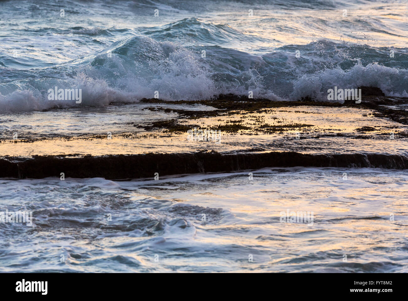 Ocean waves splash over calm rock shelf at dawn Stock Photo - Alamy
