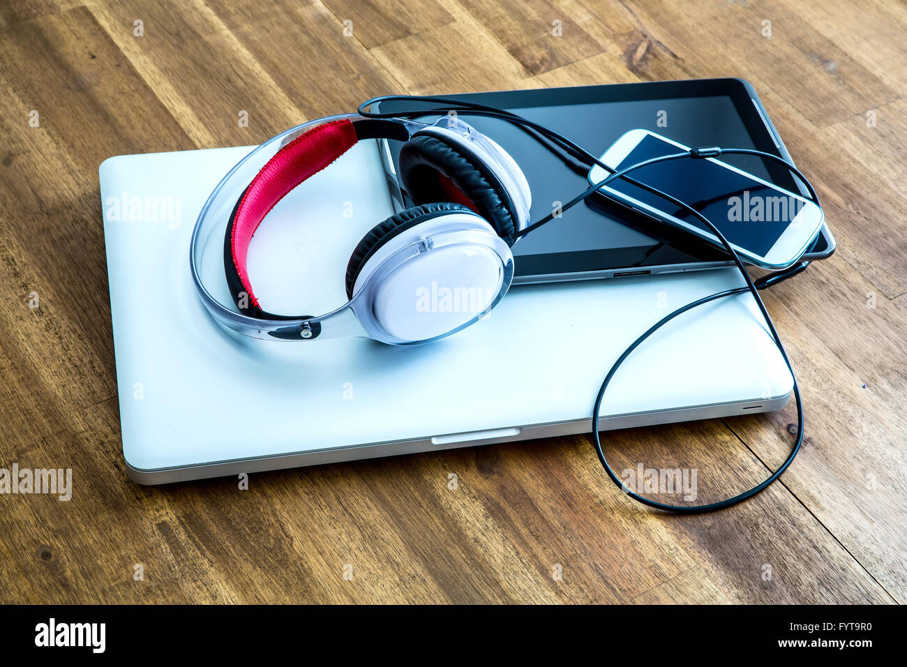 Digital devices and Headphones on a wooden Desktop Stock Photo - Alamy