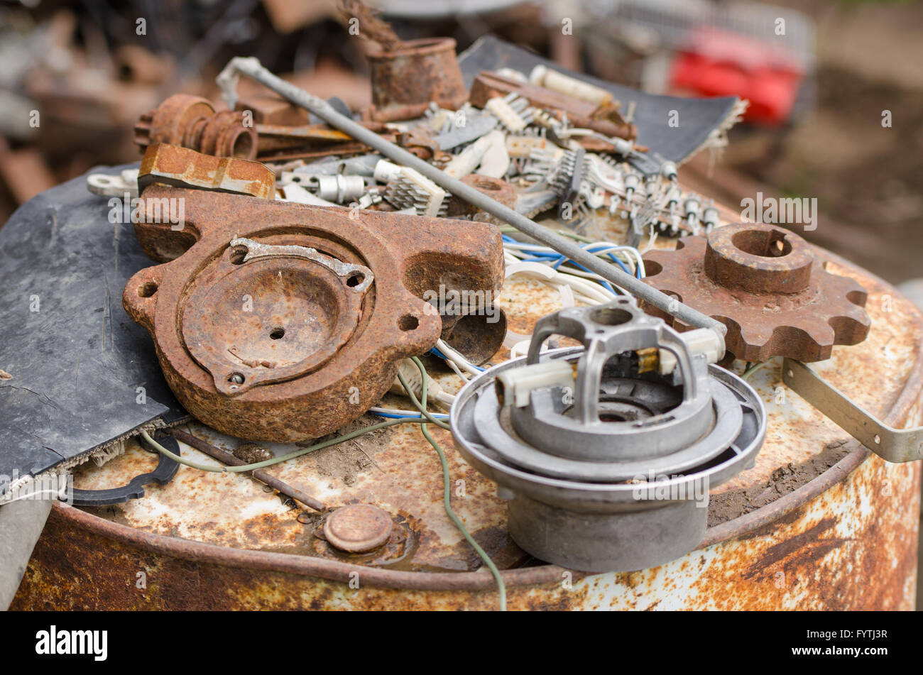 A pile of old broken pieces of iron lying on a rusty barrel Stock Photo ...