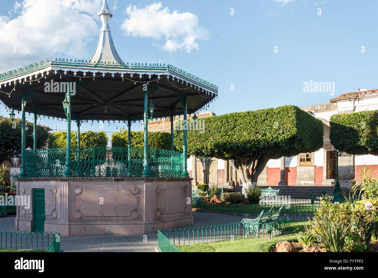 A gazebo at a plaza with trees cut into square shapes in Quiroga ...