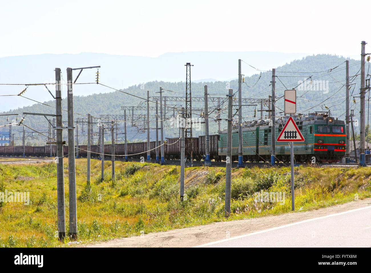 Big green electric locomotive with cars going by rail Stock Photo - Alamy