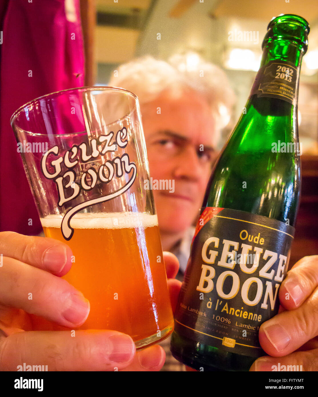 BRUSSELS, BELGIUM - Man at cafe holding glass and bottle of Geuze Boon ...