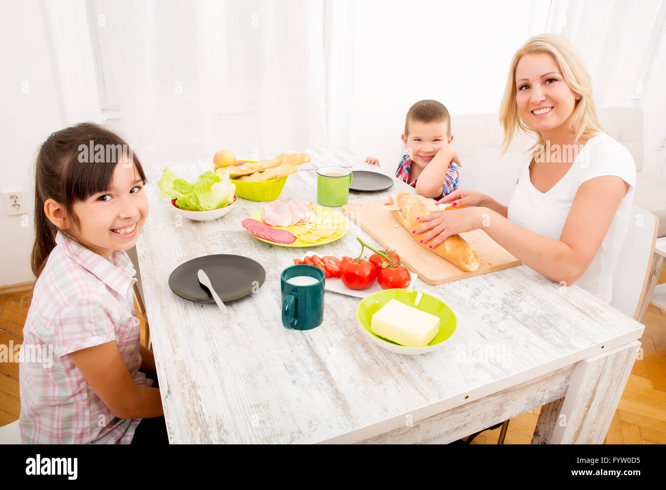 Happy family having breakfast at home Stock Photo - Alamy