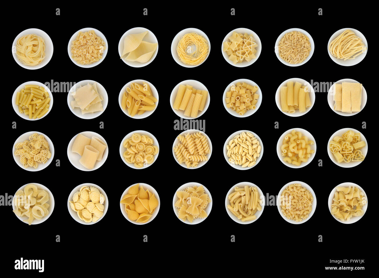 Dried spaghetti pasta food sampler in round porcelain bowls over black ...