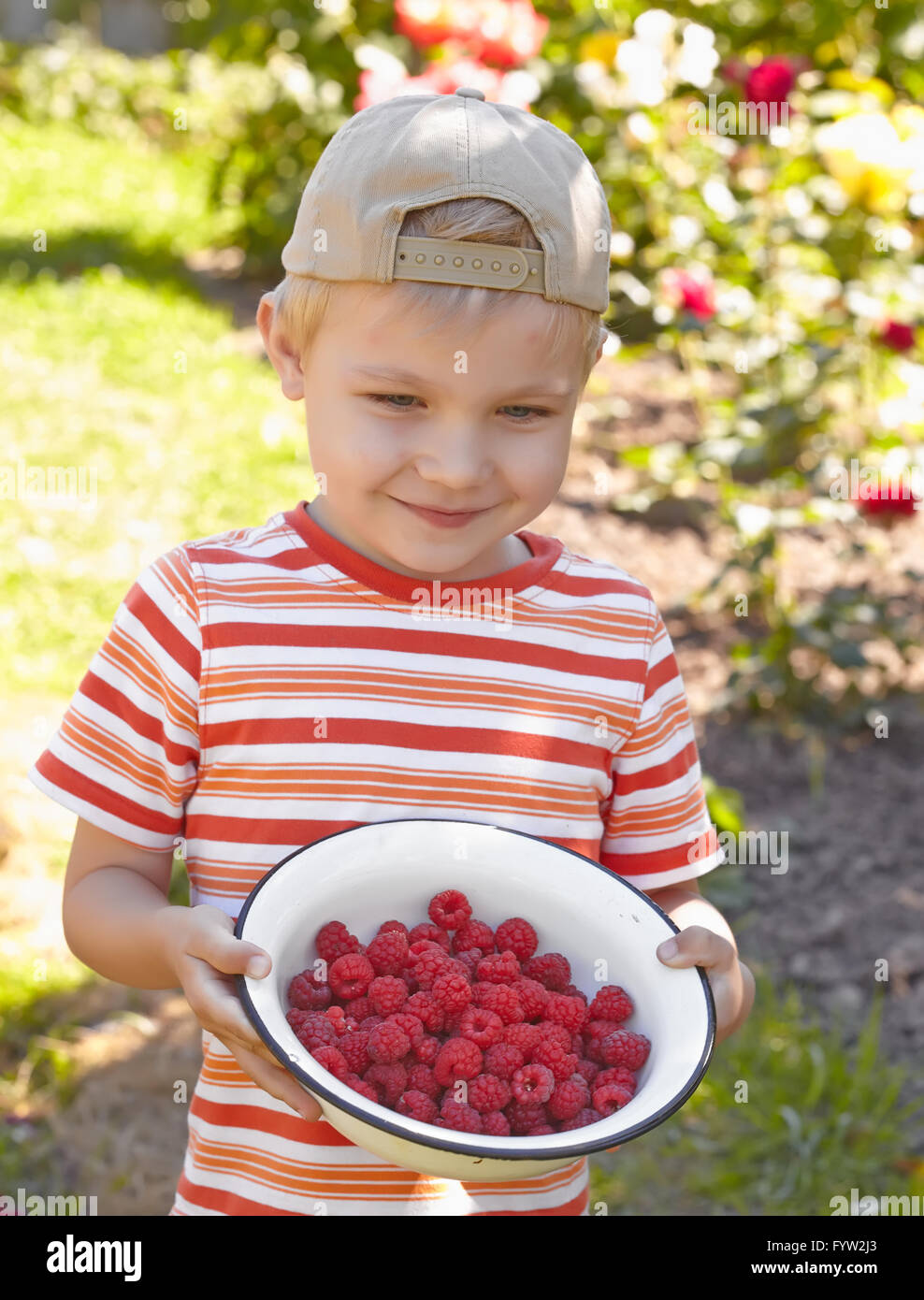 Funny kid boy with bowl of a raspberry Stock Photo - Alamy