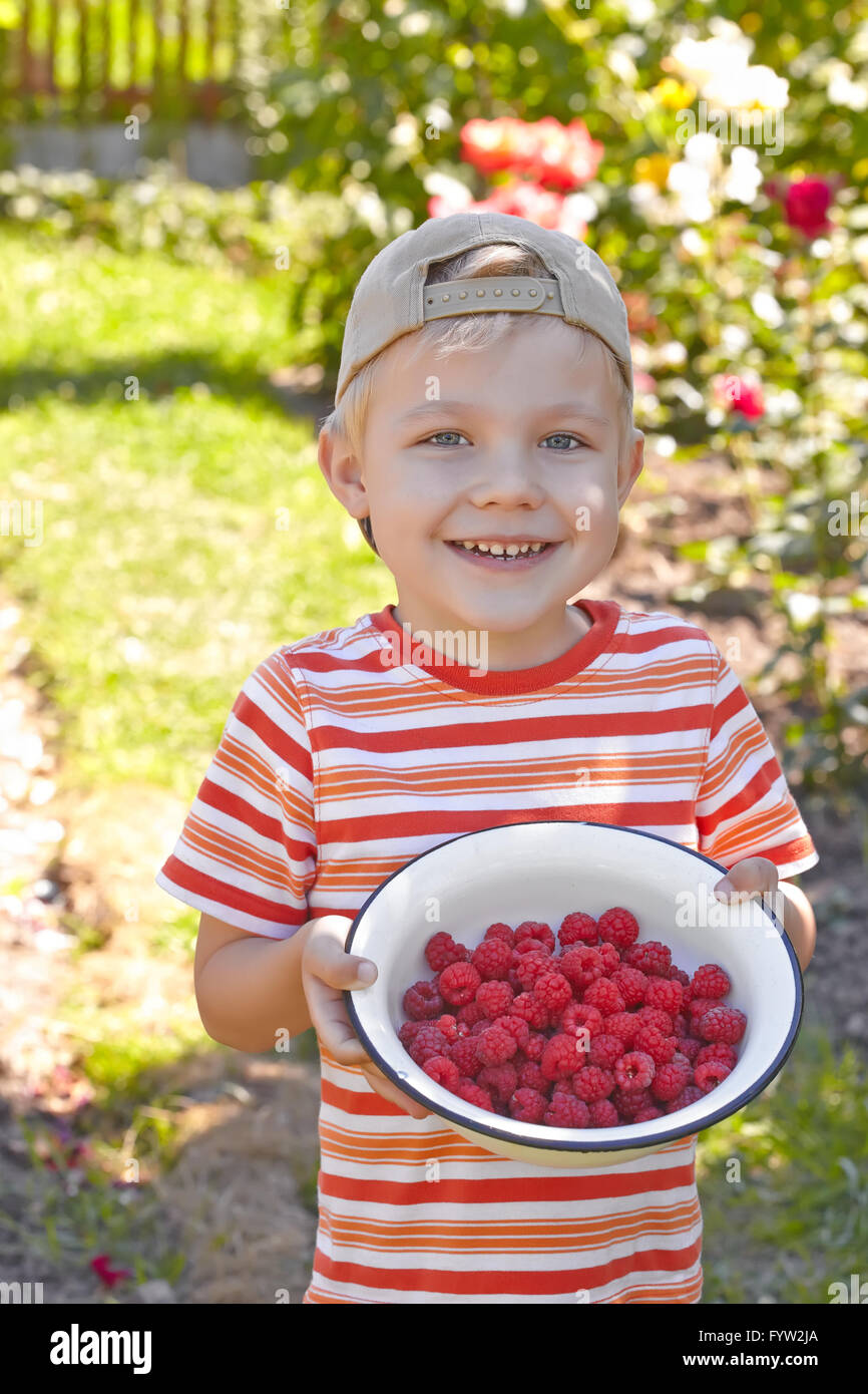 Funny kid boy with bowl of a raspberry Stock Photo - Alamy
