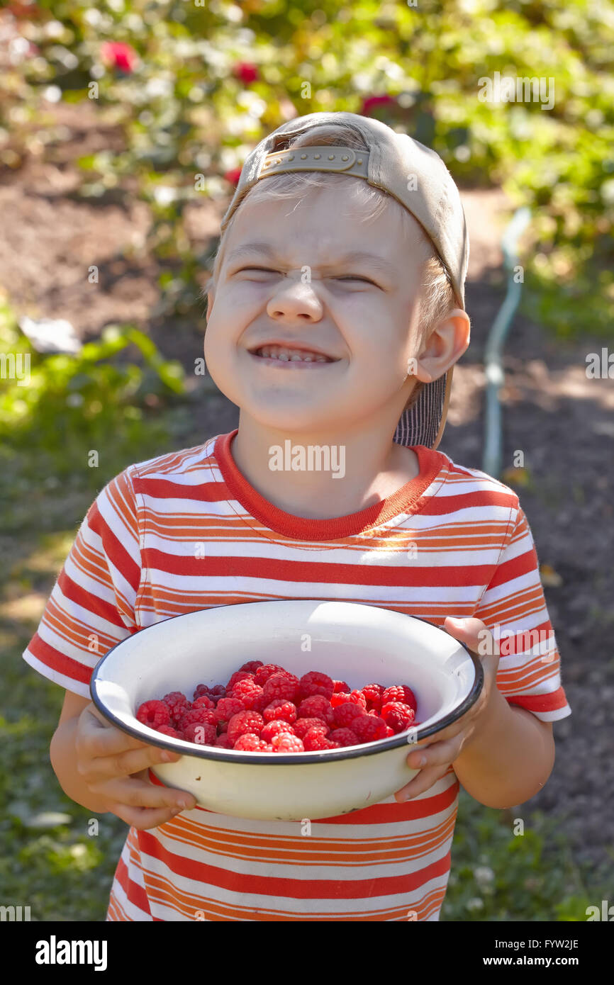 Funny kid boy with bowl of a raspberry Stock Photo - Alamy
