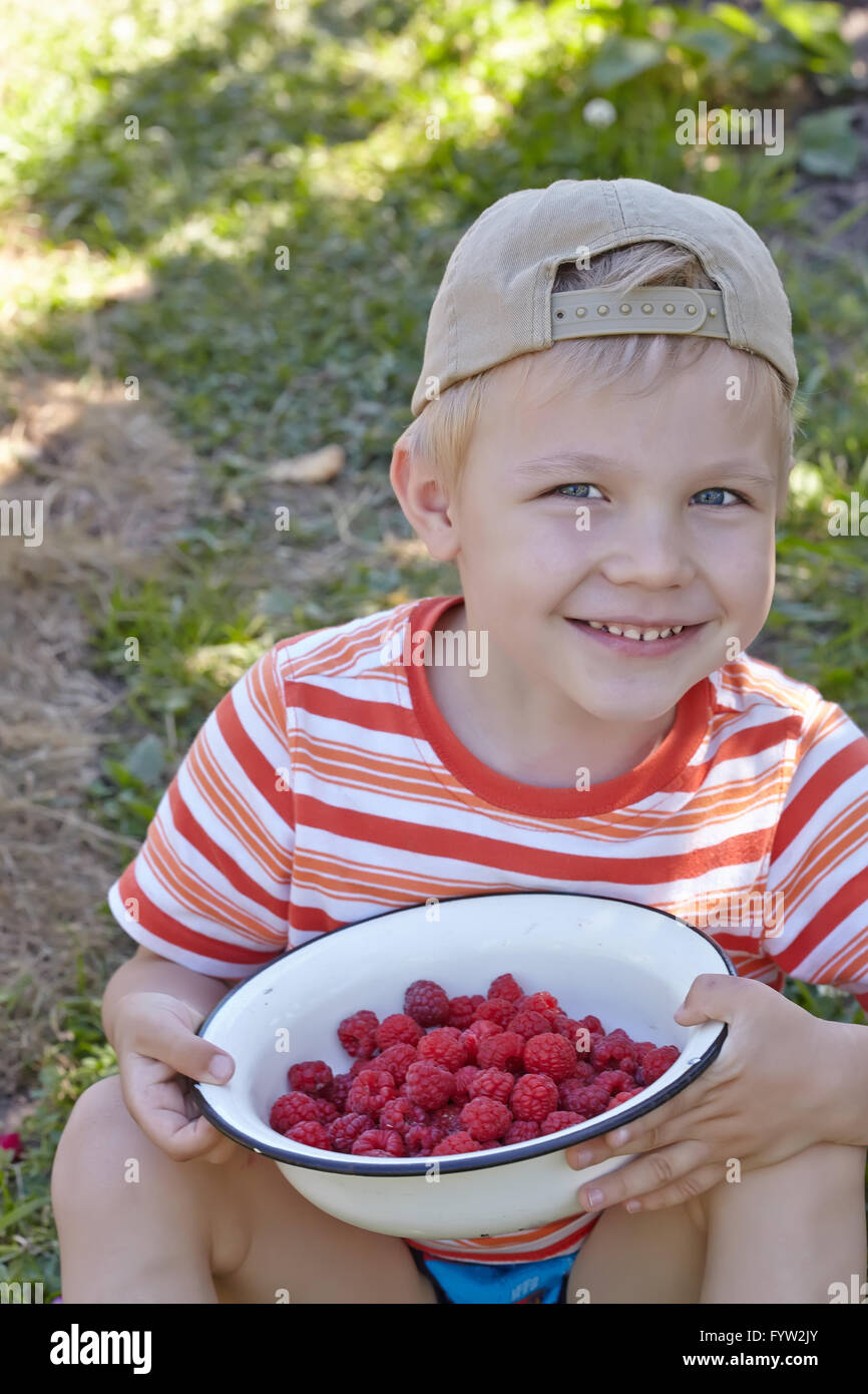 Funny kid boy with bowl of a raspberry Stock Photo - Alamy
